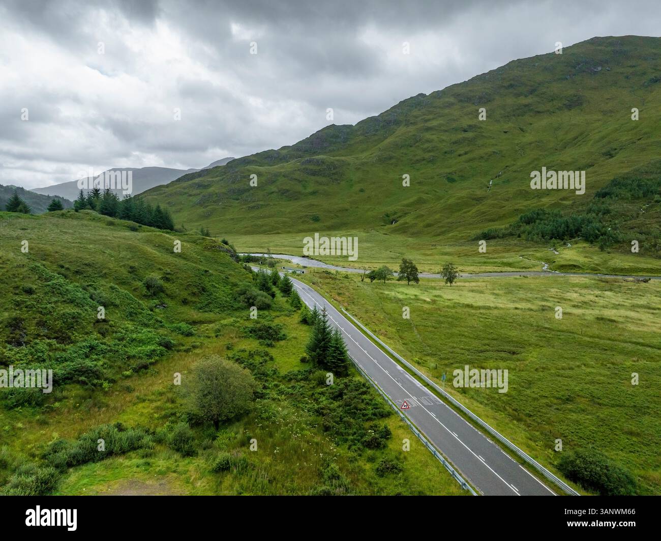 Aerial view of winding road through lush green mountains in the serene ...