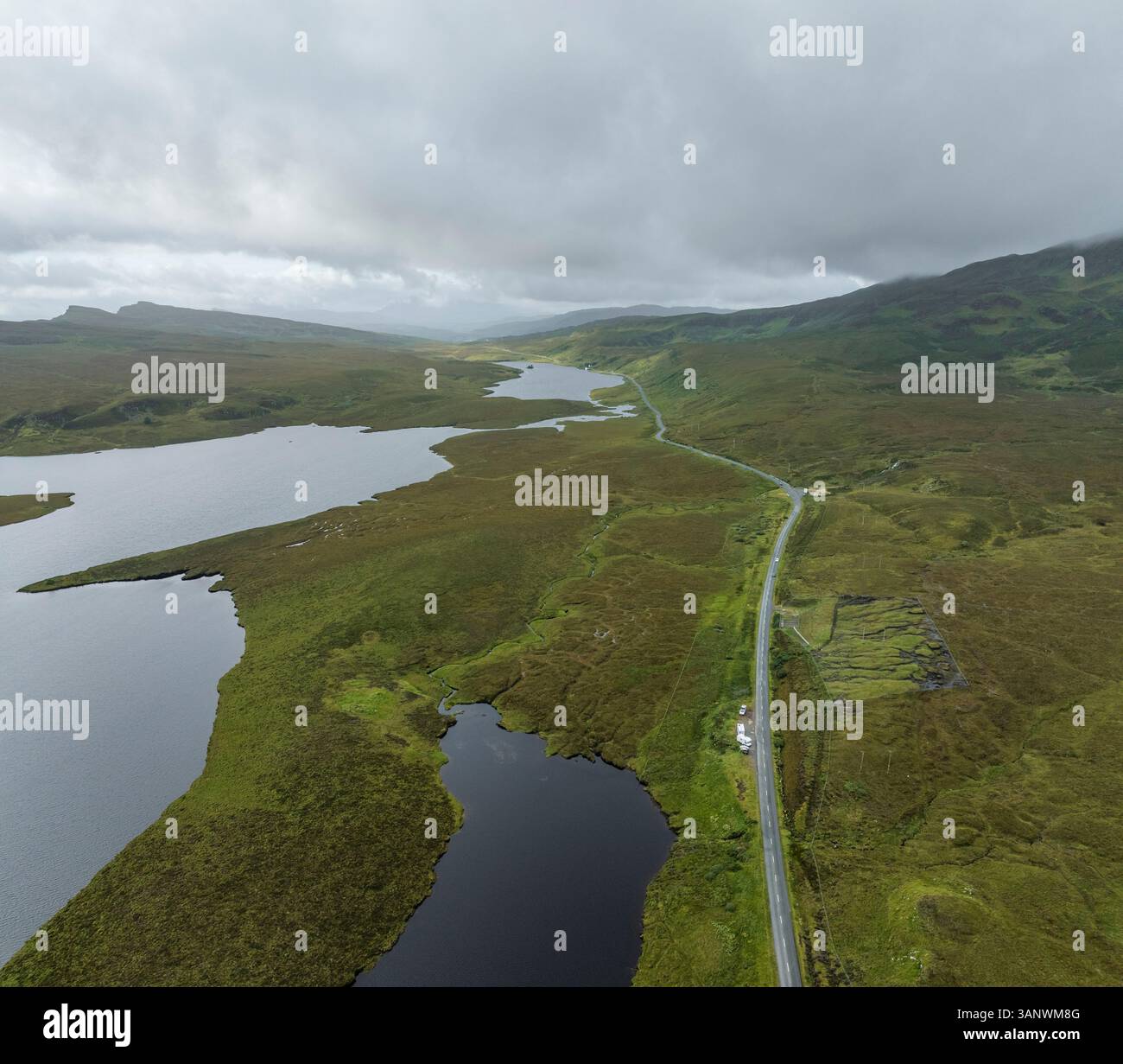 Aerial view of the serene Loch Leathan surrounded by majestic mountains ...