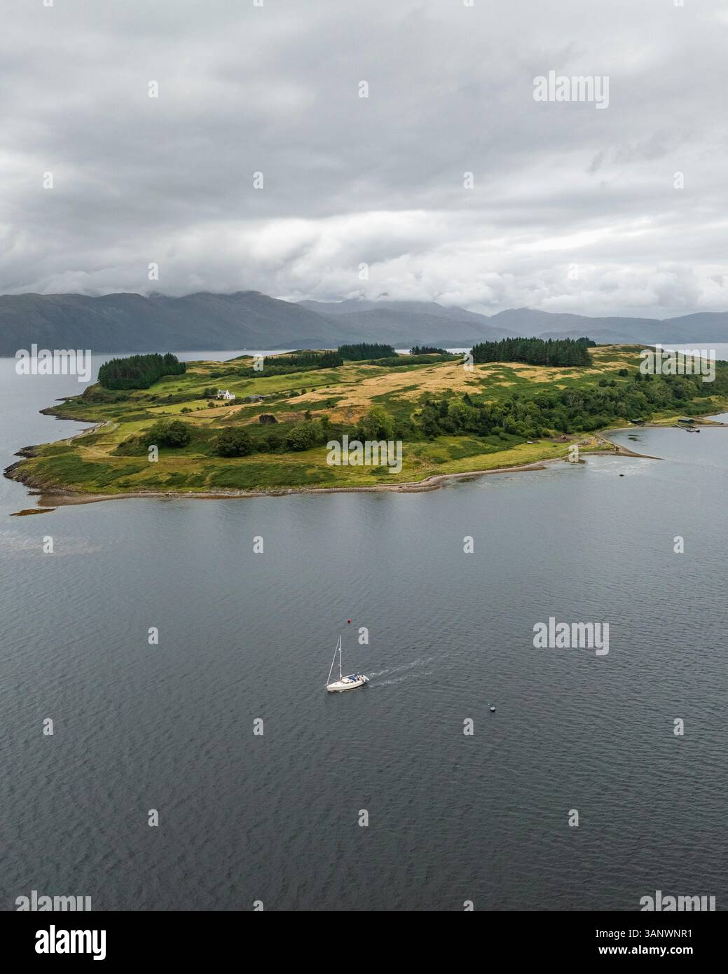 Aerial view of serene Shuna Island on tranquil Loch Linnhe with a boat ...