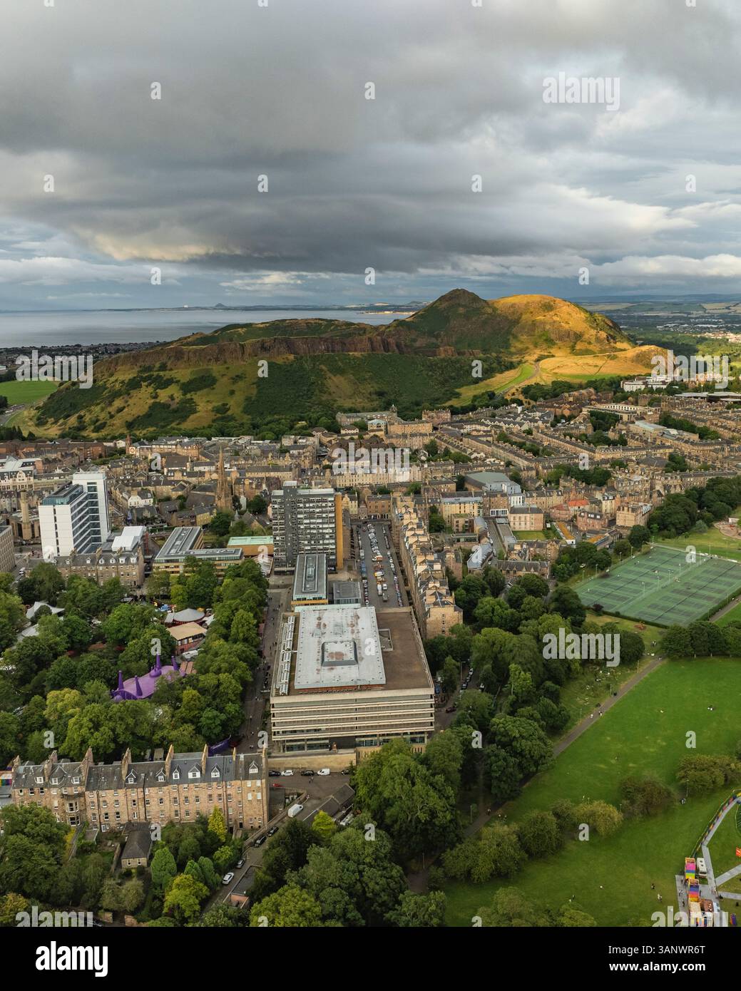 Aerial view of arthur seat volcano surrounded by urban buildings and ...