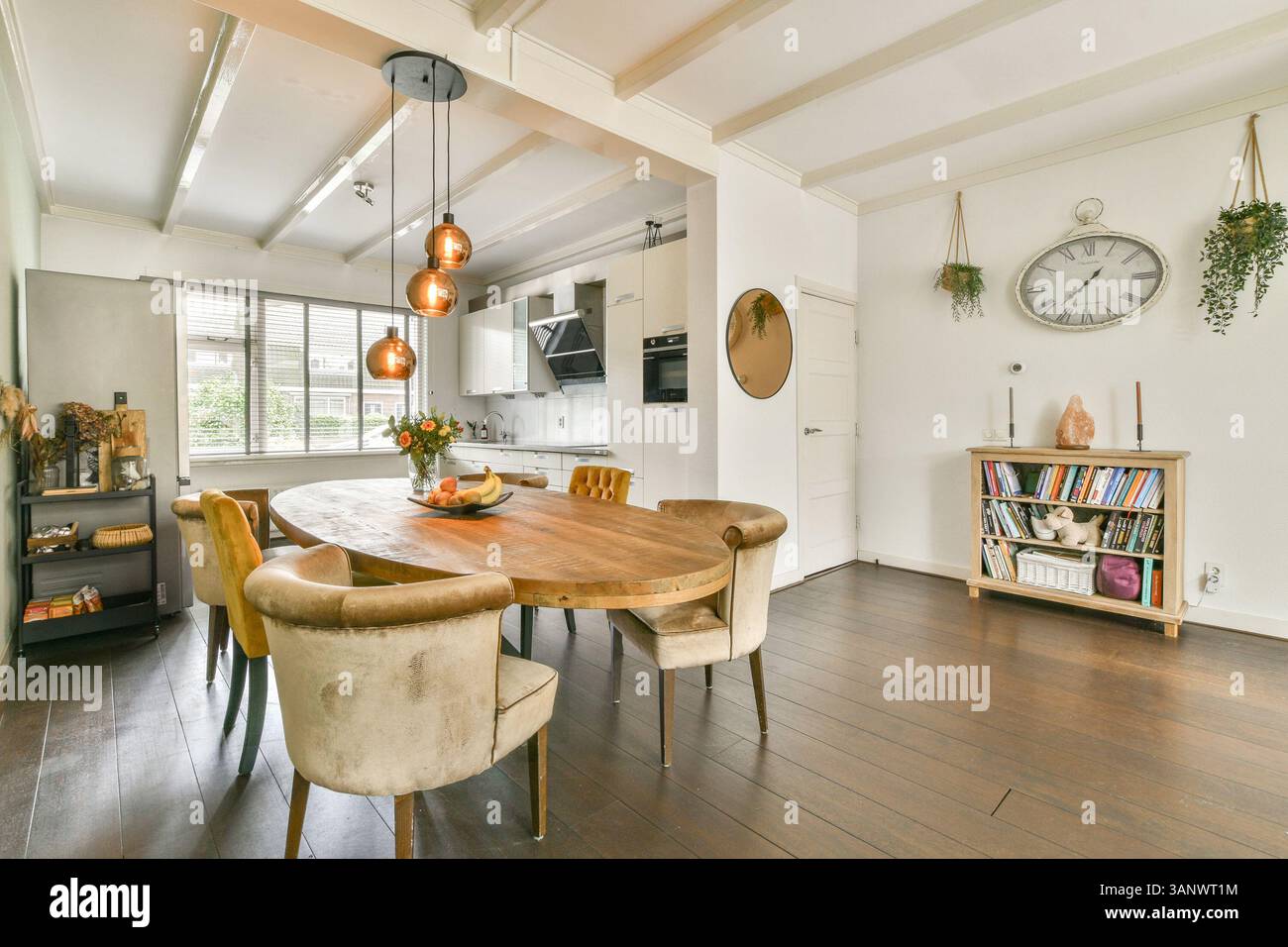 A stylish dining area featuring a round wooden table, elegant chairs ...
