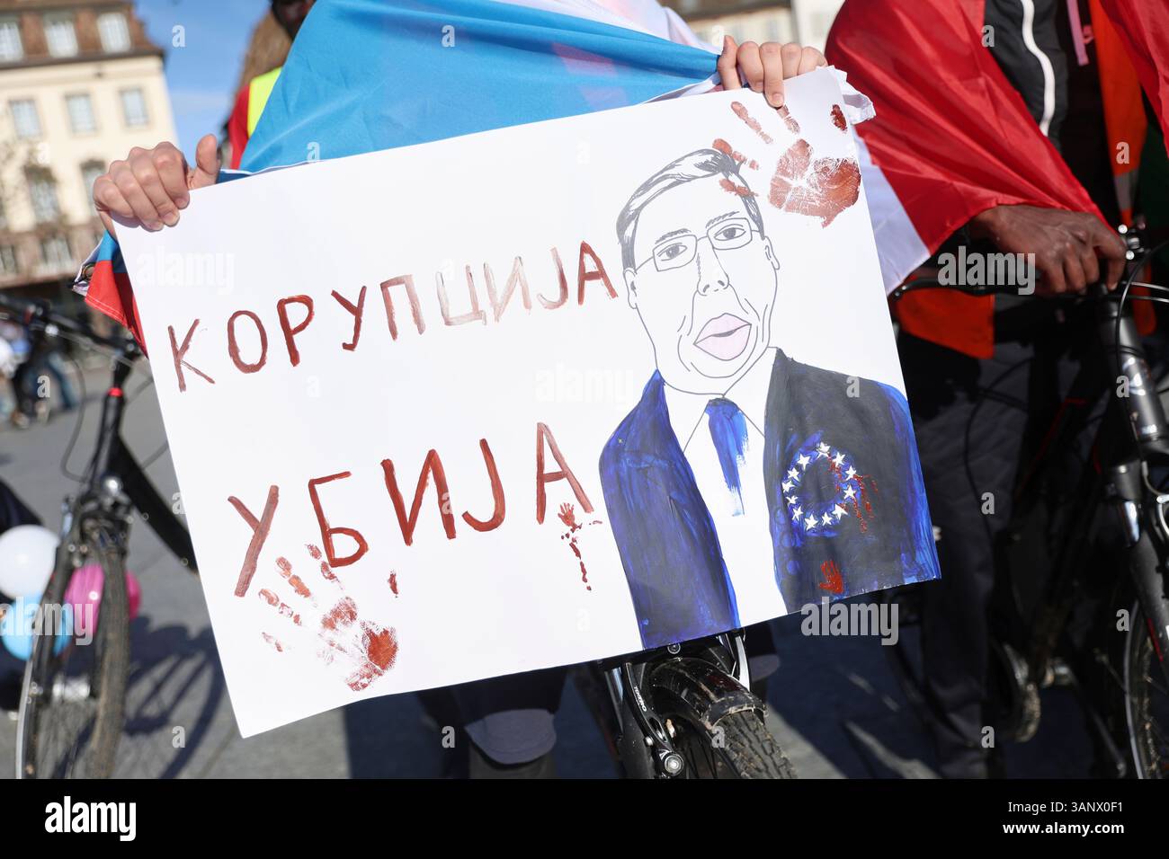 Protesters hold a poster showing Serbian President Aleksandar Vucic ...