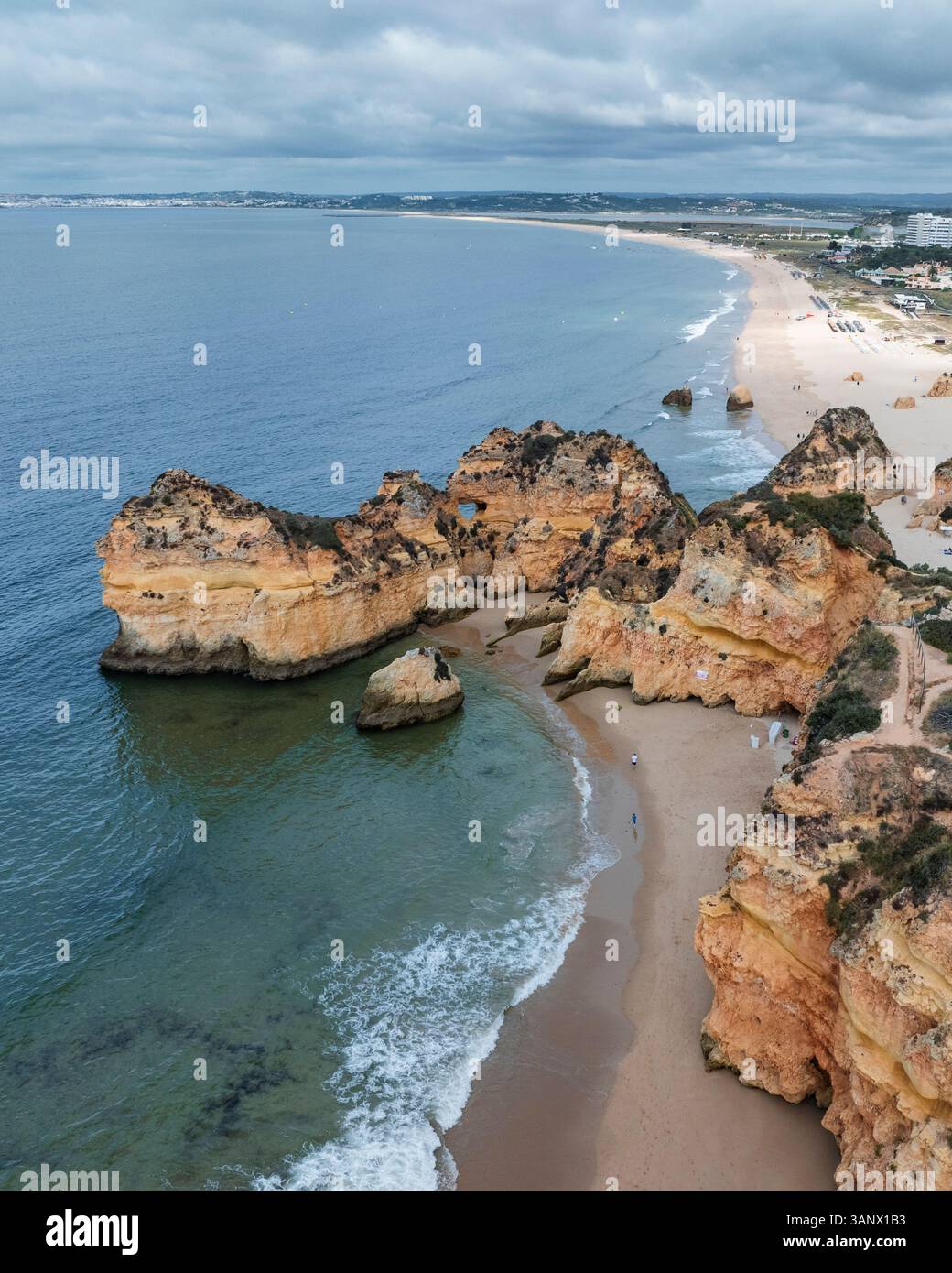 Aerial view of sandy beach and cliffs at Praia dos Tres Irmaos, Alvor ...