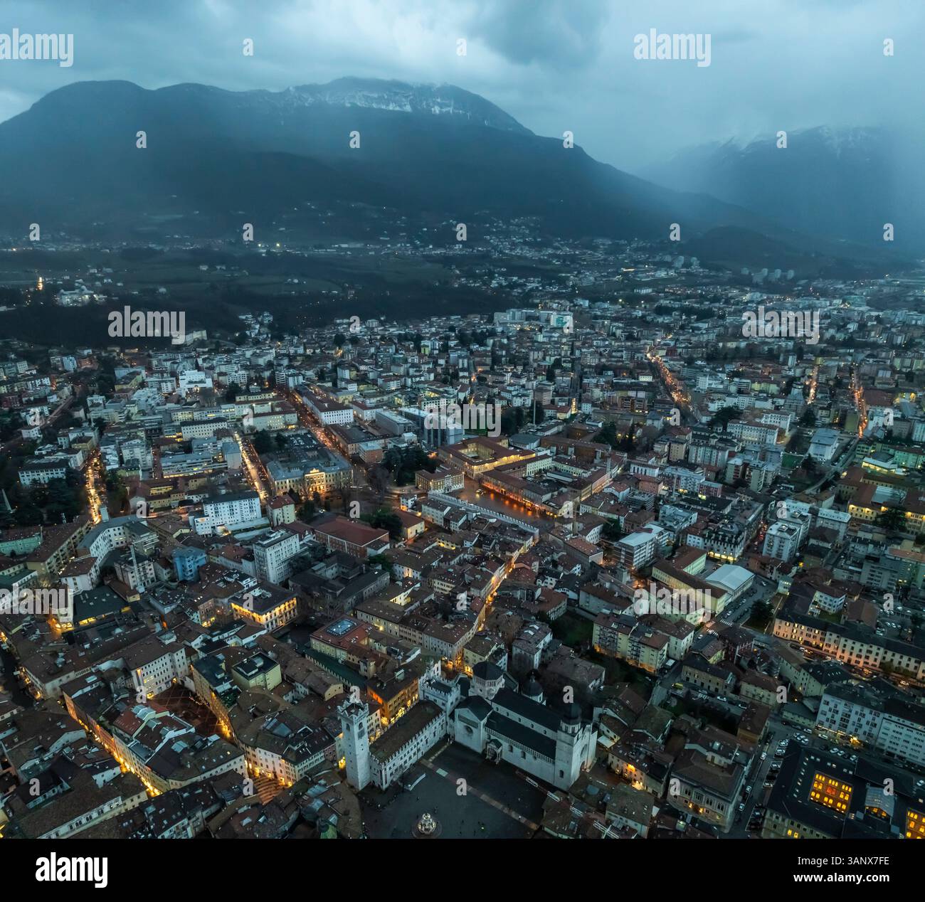 Aerial view of beautiful, scenic Trento at dusk with mountain backdrop ...