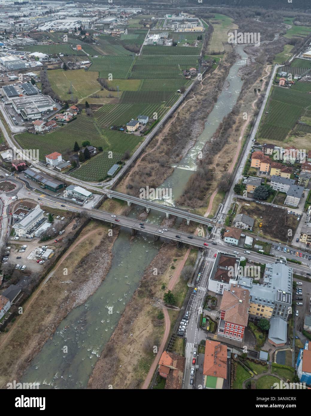 Aerial view of Lavis, Trento with Avisio river, creek, road, and ...