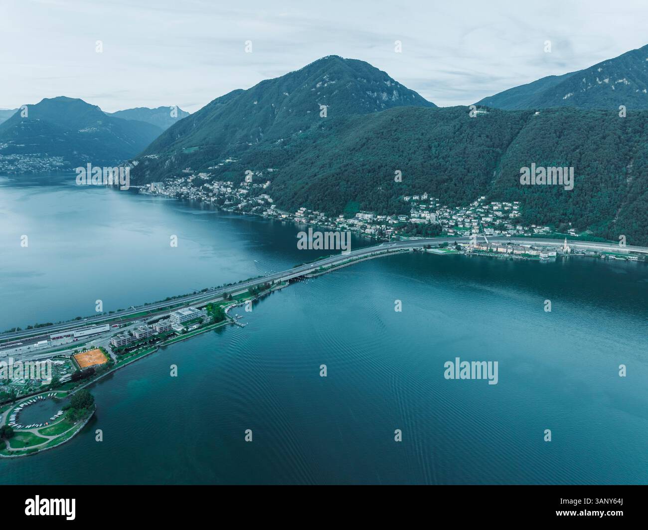 Aerial view of a road crossing the Lugano lake at sunset, Melide ...