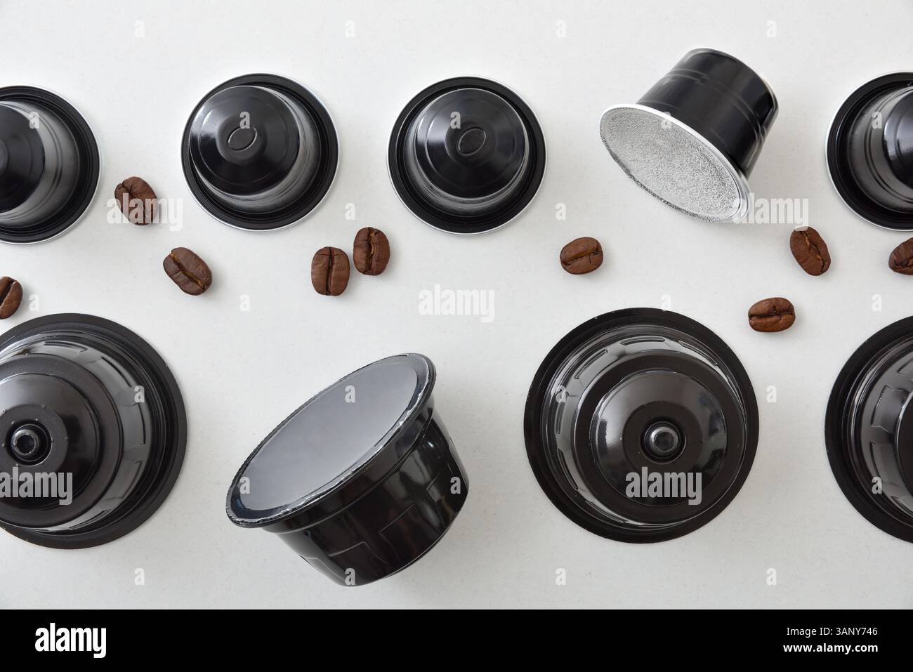 Various types of espresso coffee capsules in a row and coffee beans on ...