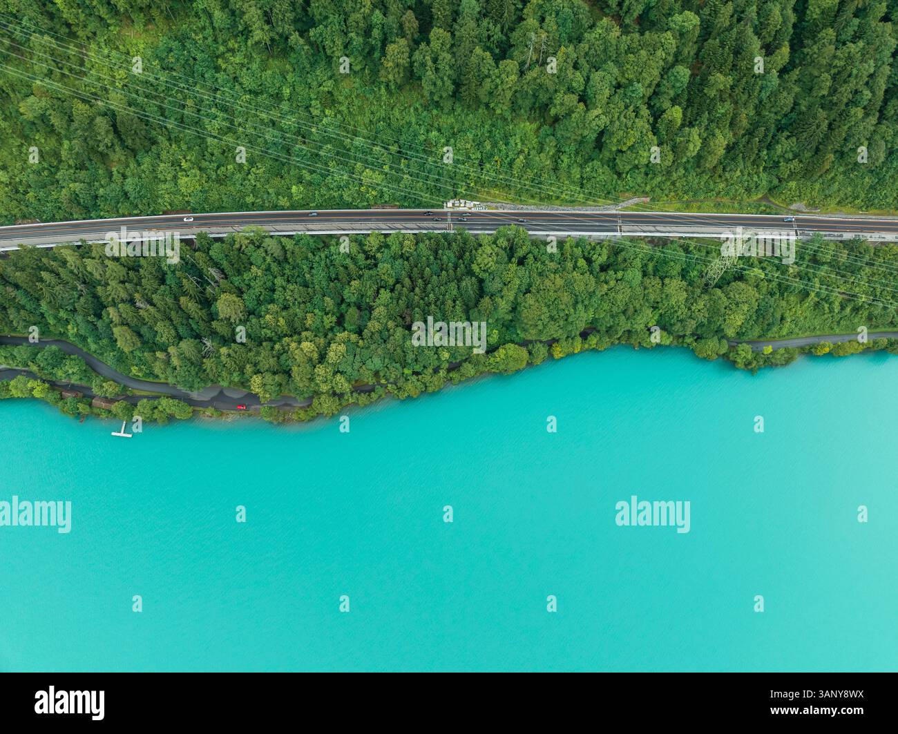 Aerial view of vehicles driving on a road following the Brienzersee ...