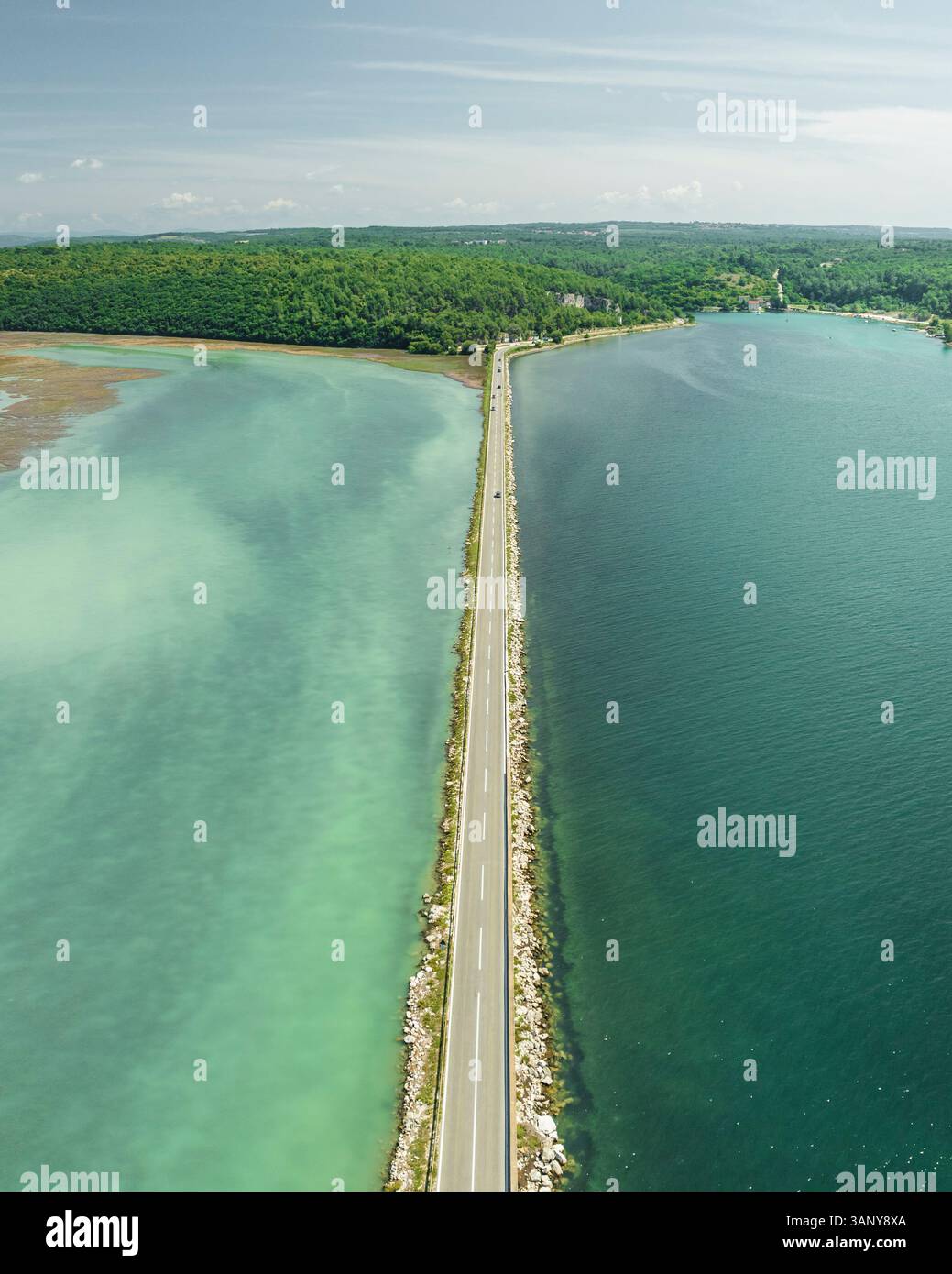 Aerial view of vehicles driving a road crossing the Mirna lagoon and ...