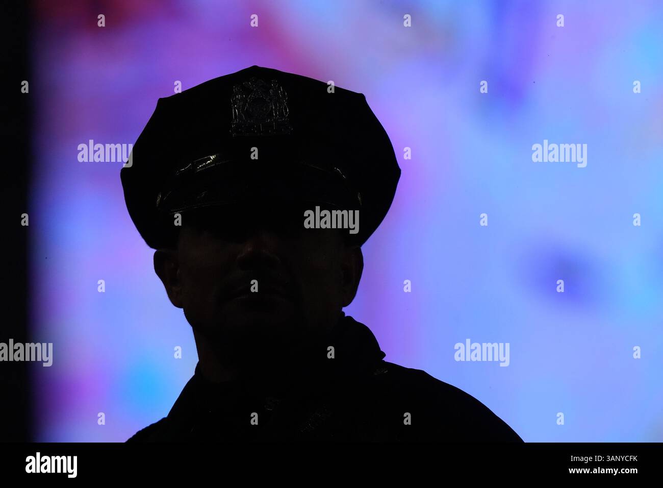 A police officer looks into the stands before the start of a baseball ...