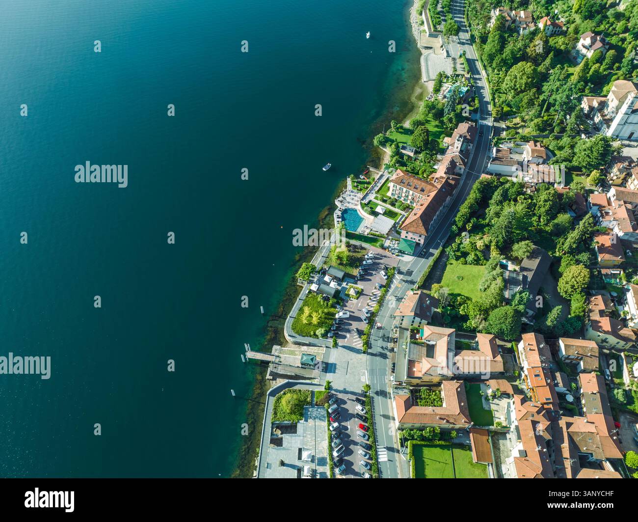 Aerial view of Meina, a small town with a road on the coastline along ...
