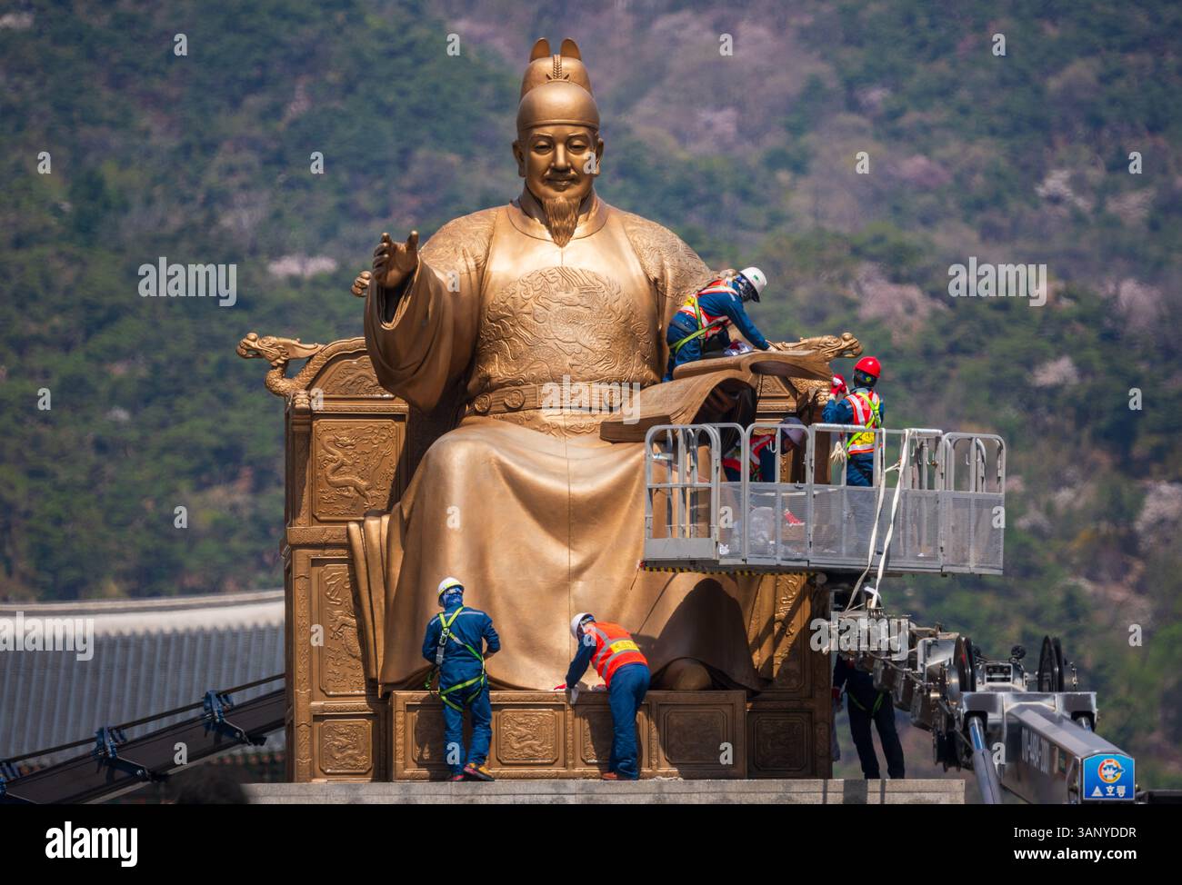 Workers clean the statue of King Sejong the Great at Gwanghwamun Square ...