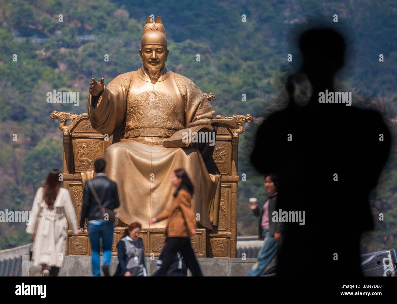 People walk by the statue of King Sejong the Great at Gwanghwamun ...