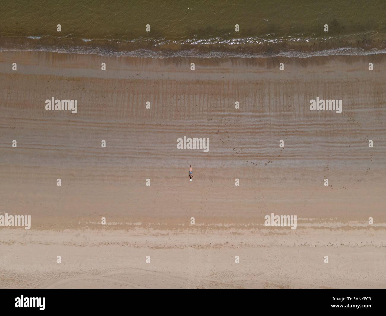 Aerial view of a person along the shoreline with a book at Baia de Sao ...