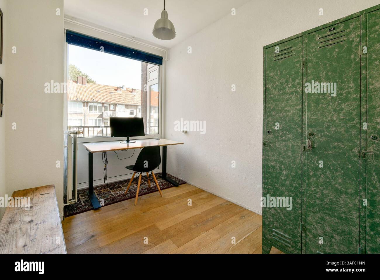 A stylish modern workspace featuring a simple desk setup, green lockers ...