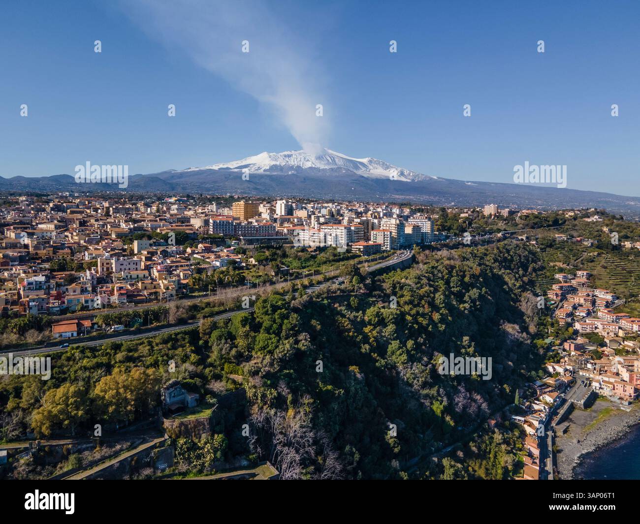 Aerial view of Acireale with Etna Volcano during eruption in background ...