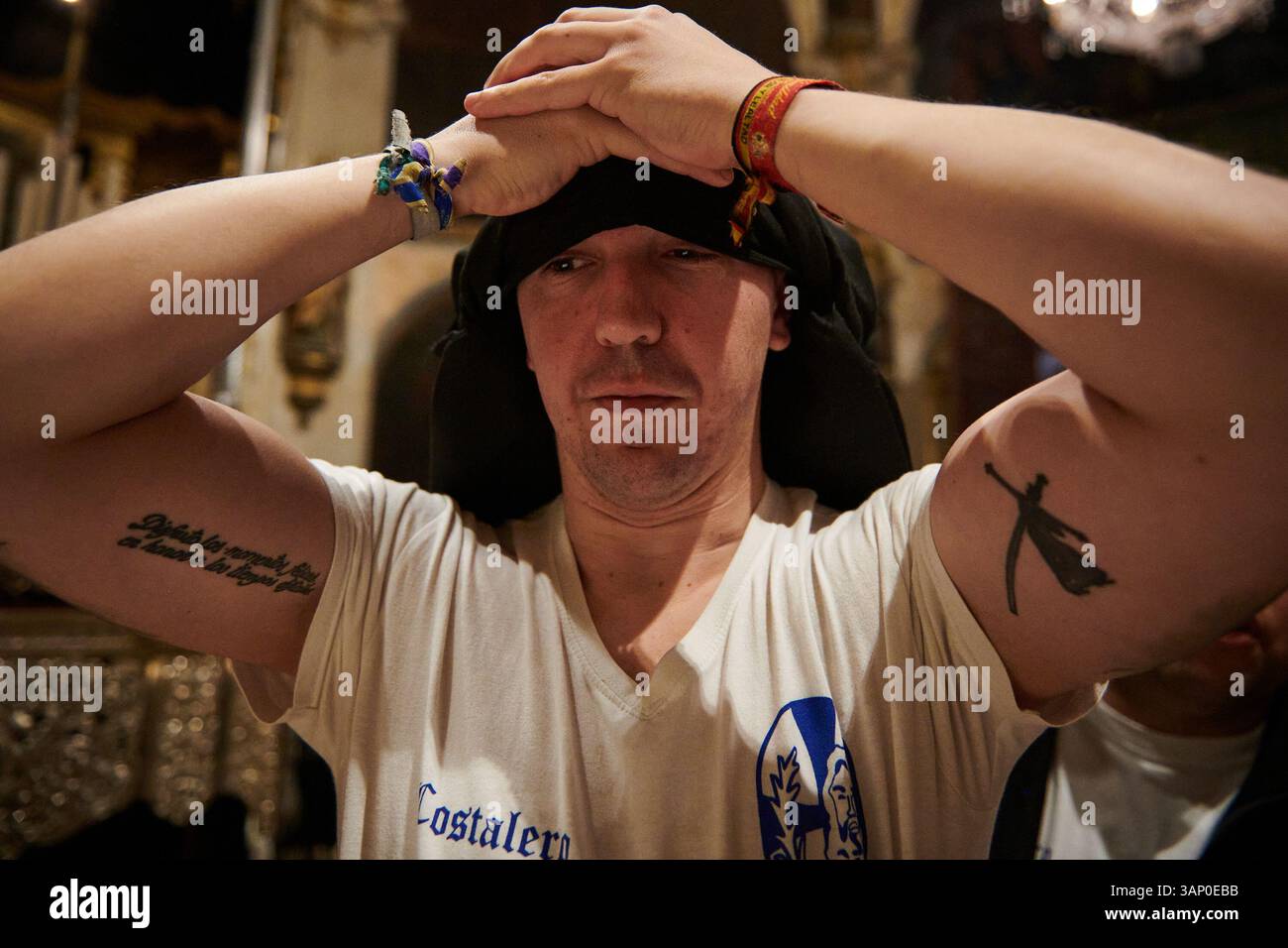 A porter known as "Costaleros" prepares before taking part in the Holy ...