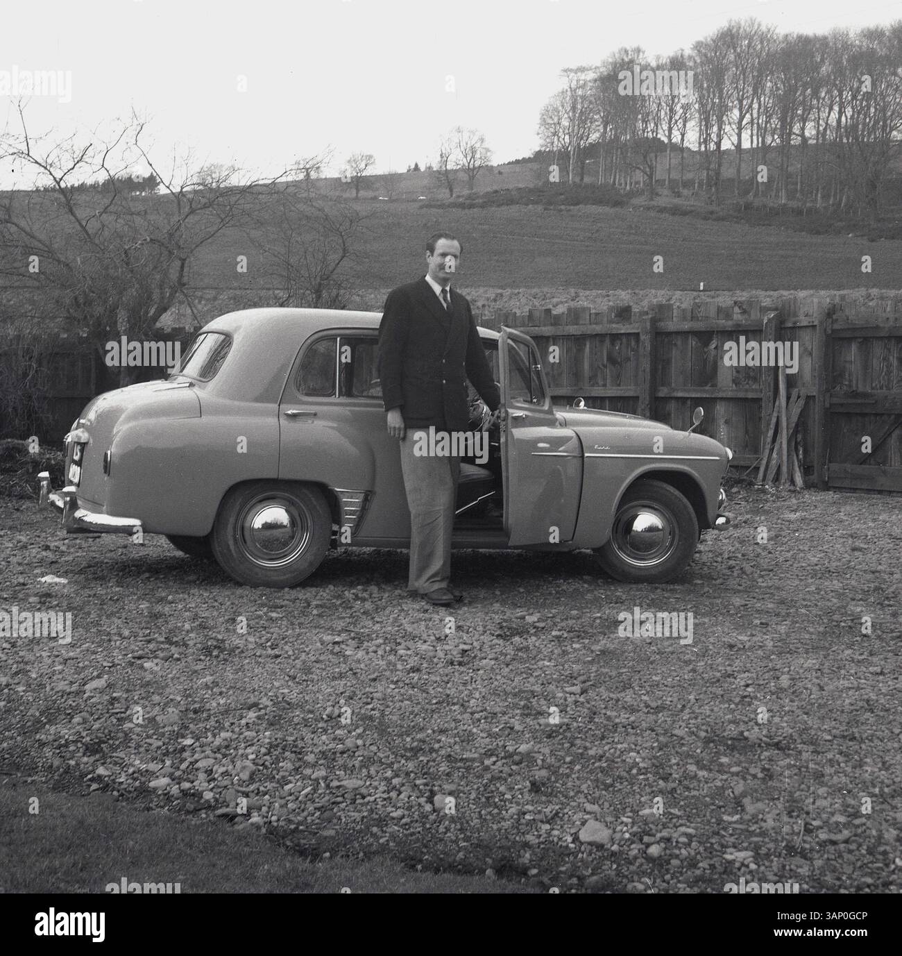 1950s, historical, Richard Irvine standing outside his Hillman Minx ...