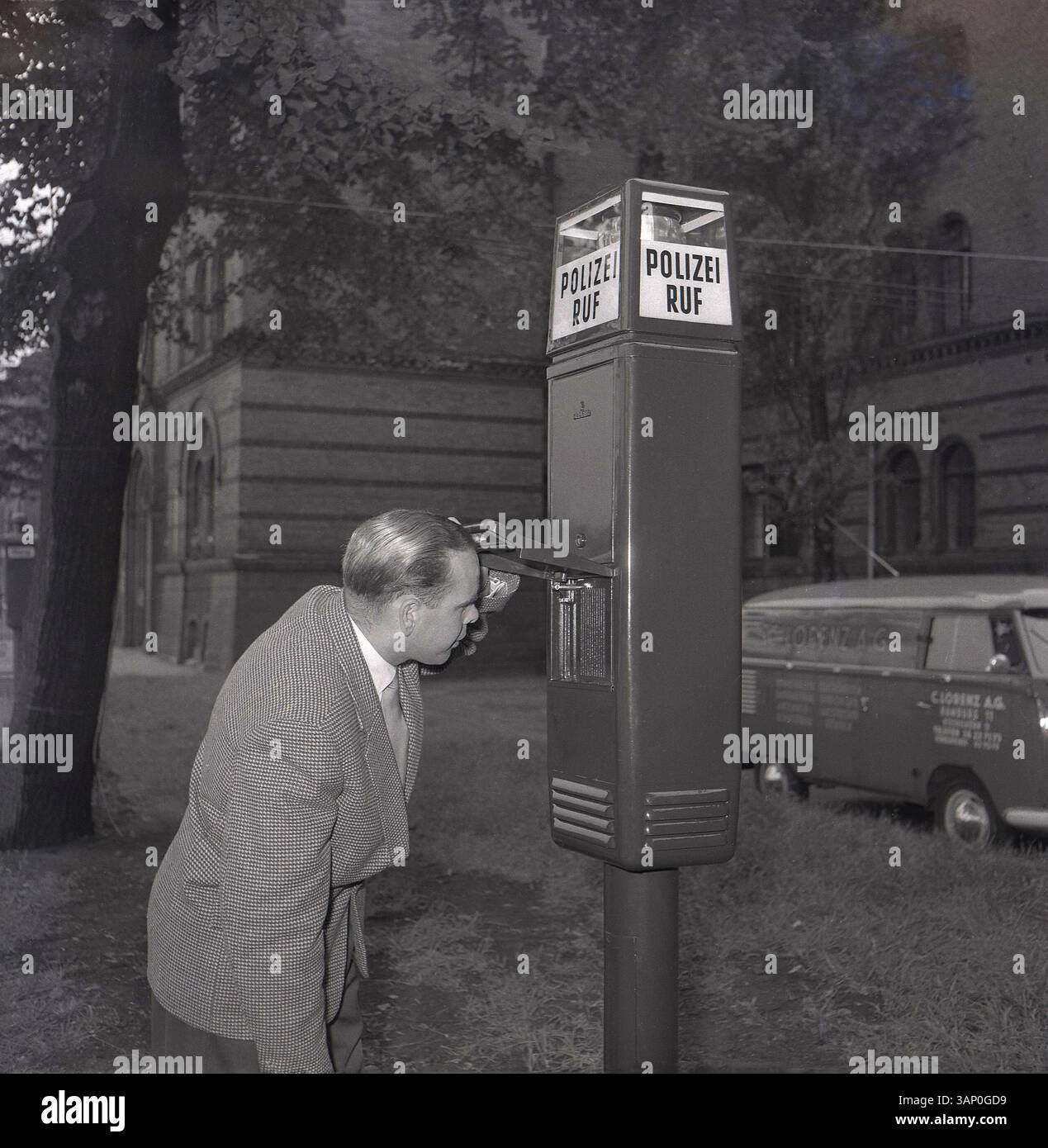 Late 1950s,, historical, a man using a new street police call/voice box ...