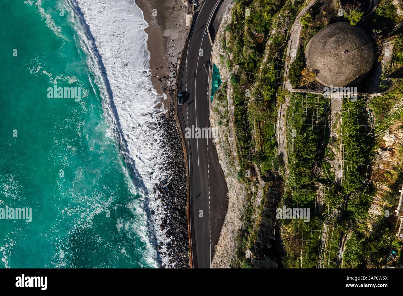 Aerial view of a car driving on the Amalfi drive road facing the ...