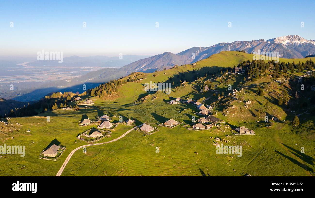 Aerial view of picturesque alpine pasture with traditional chalets and ...