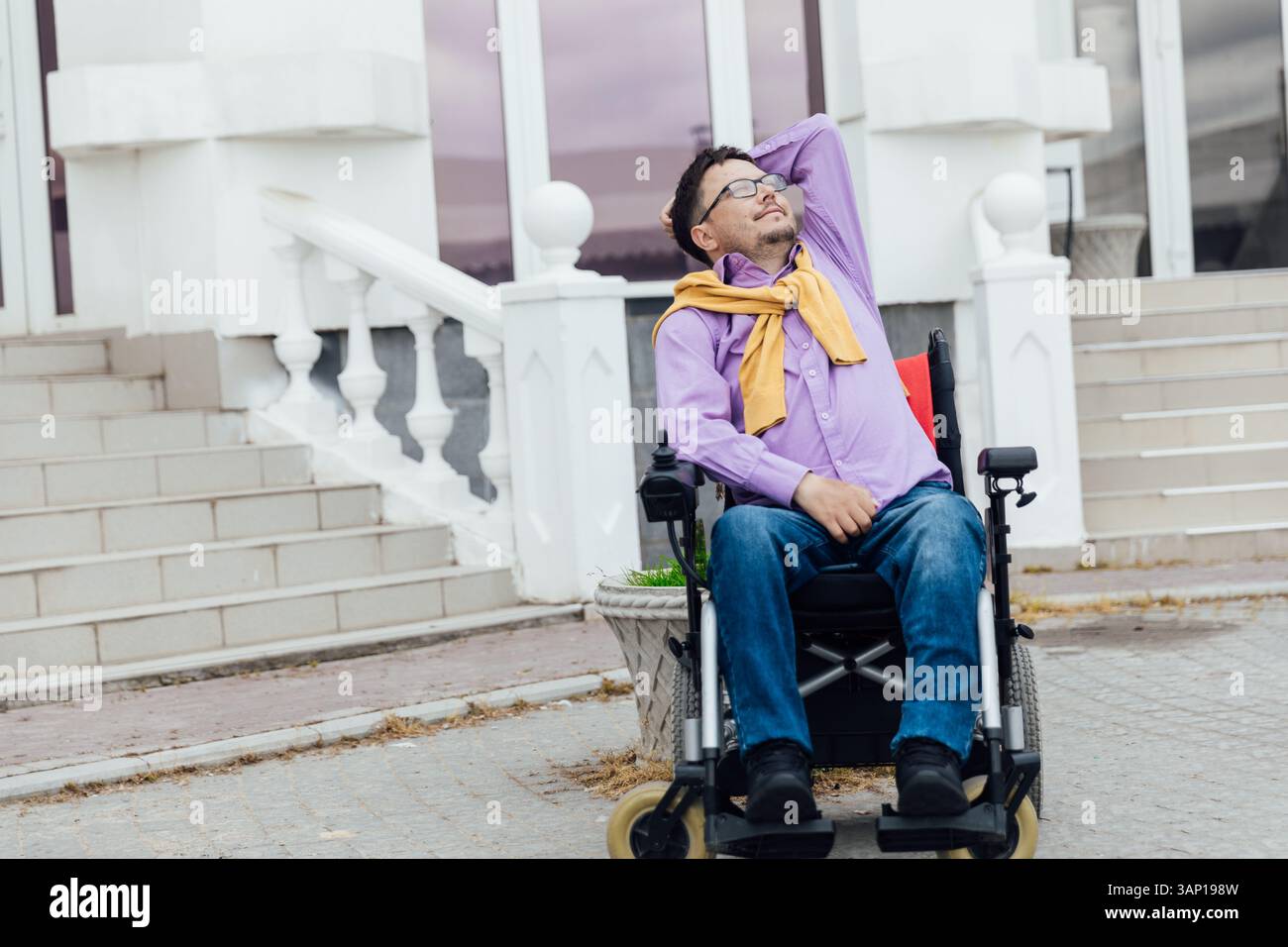 A man in a wheelchair is resting on a walk through the streets Stock ...