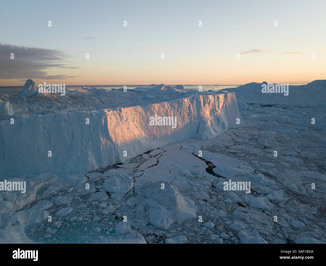 Aerial drone view of an iceberg landscape in golden sunset light at ...