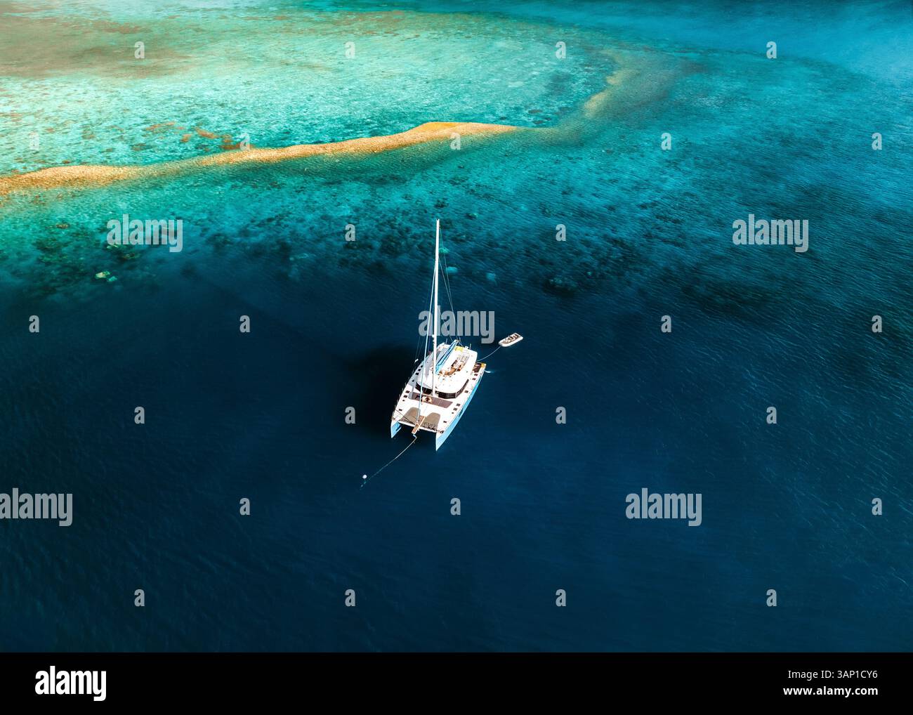Aerial view of ocean patterns and coral reefs with luxurious yachts in ...