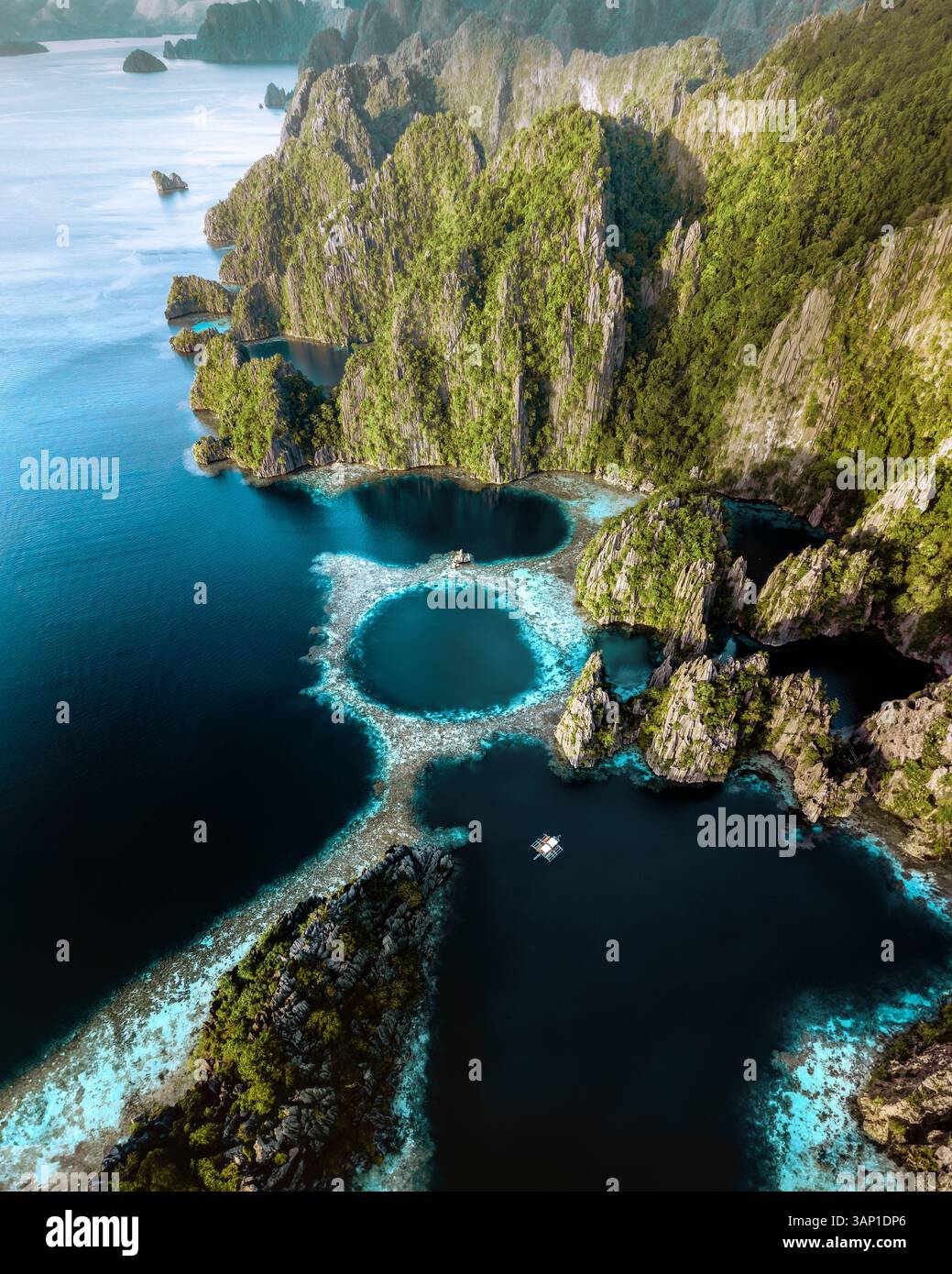 Aerial view of twin lagoons surrounded by dramatic limestone cliffs and ...