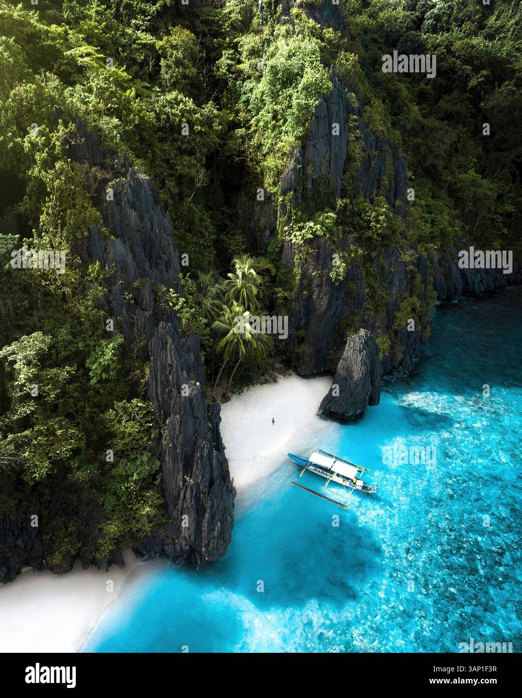 Aerial view of a person on a small beach along the wild coast with ...