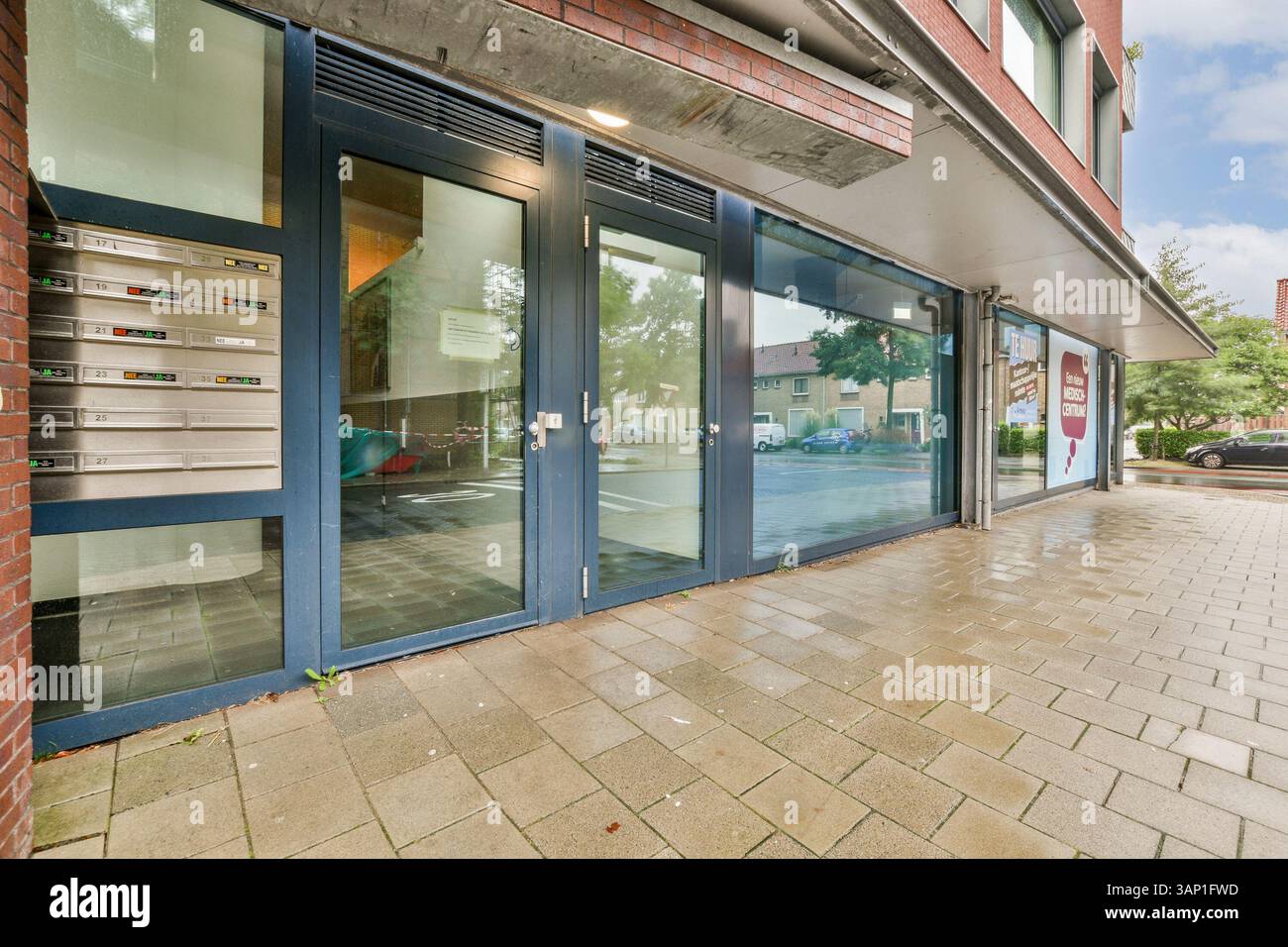 The image showcases a modern building entrance featuring large glass ...