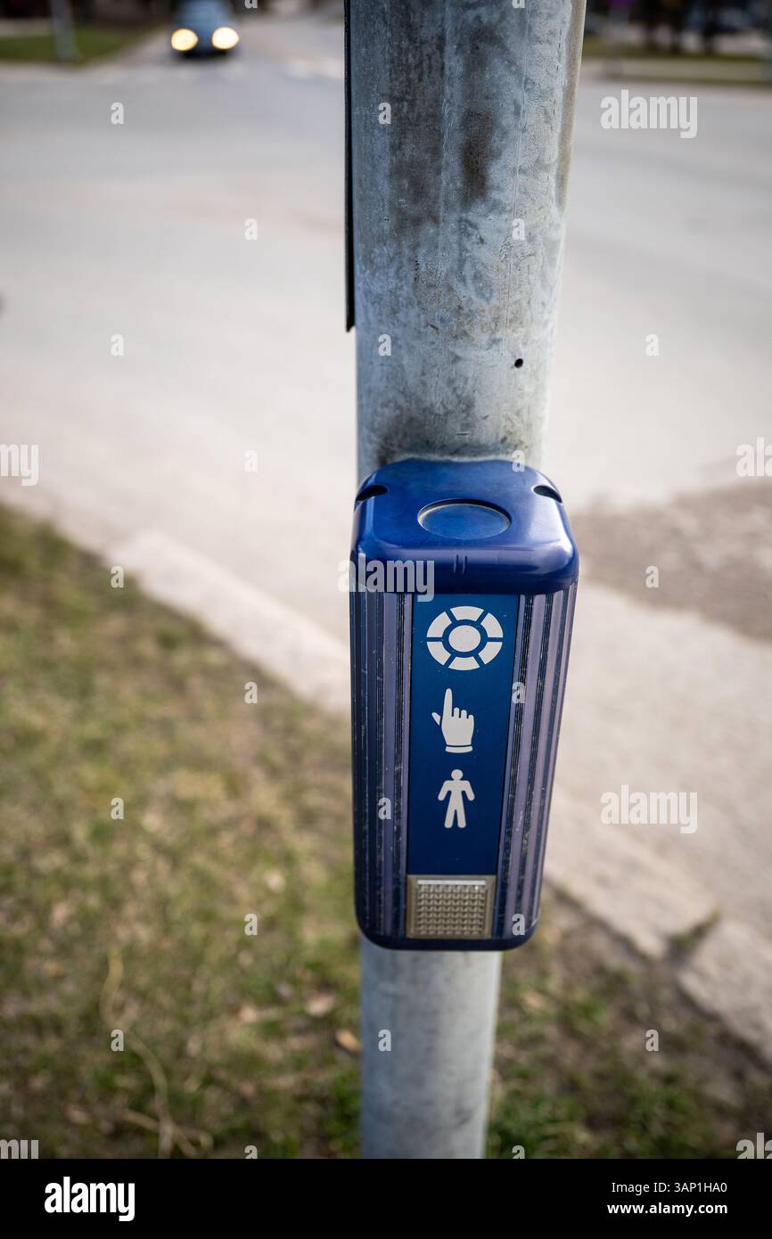 Pedestrian crossing button mounted on a metal pole beside a road Stock ...