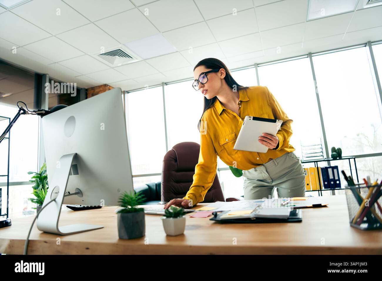 Young businesswoman working in a modern office, managing tasks ...