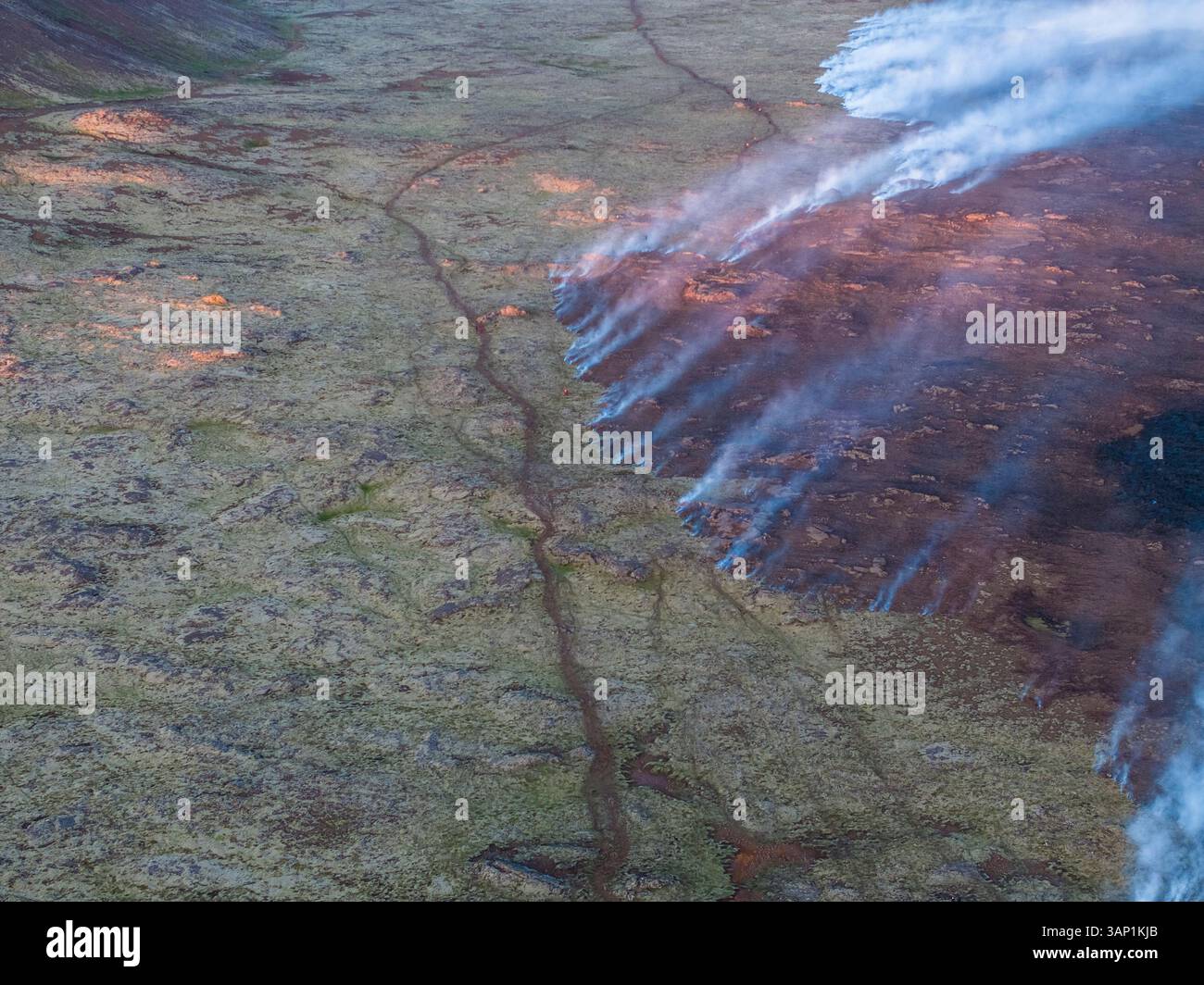 Aerial view of the magma flowing and burning grass across the valley ...