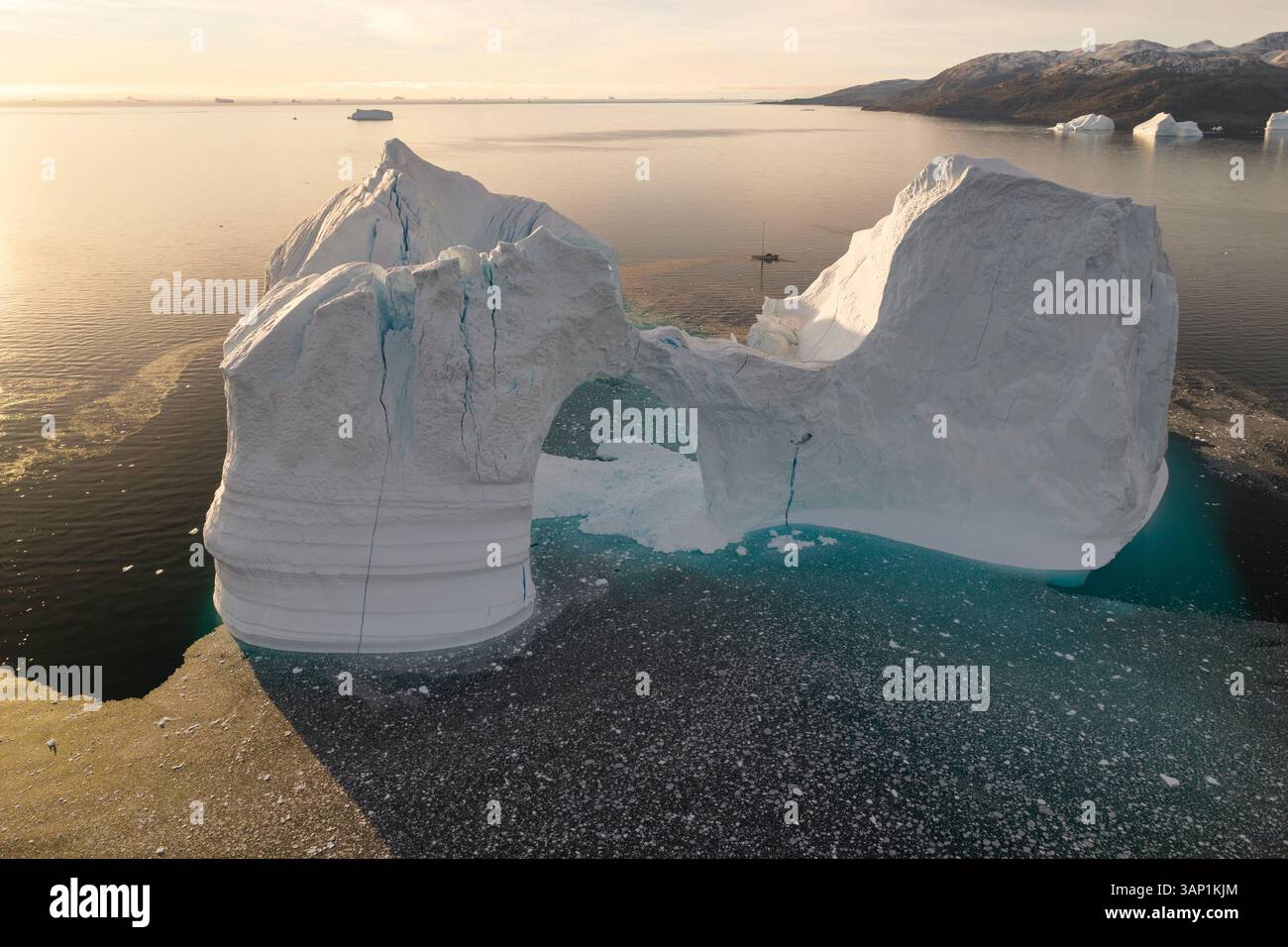 Aerial view of a big ice formation along the coast in a fjord at sunset ...