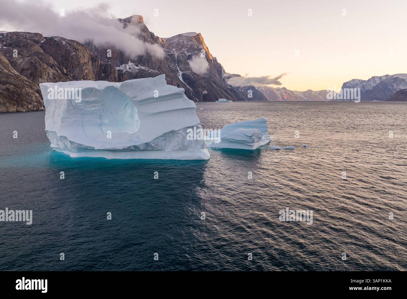 Aerial view of a big ice formation along the coast in a fjord at sunset ...
