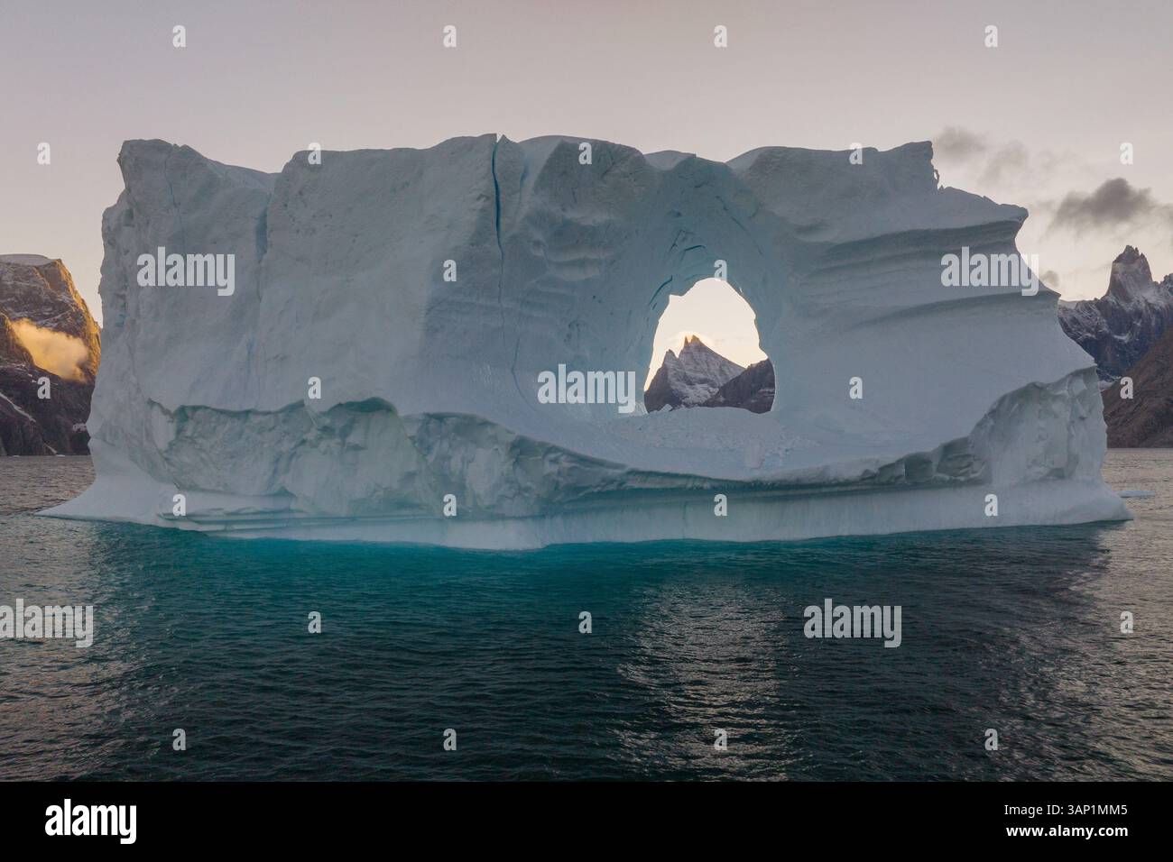 Aerial view of a big ice formation along the coast in a fjord at sunset ...