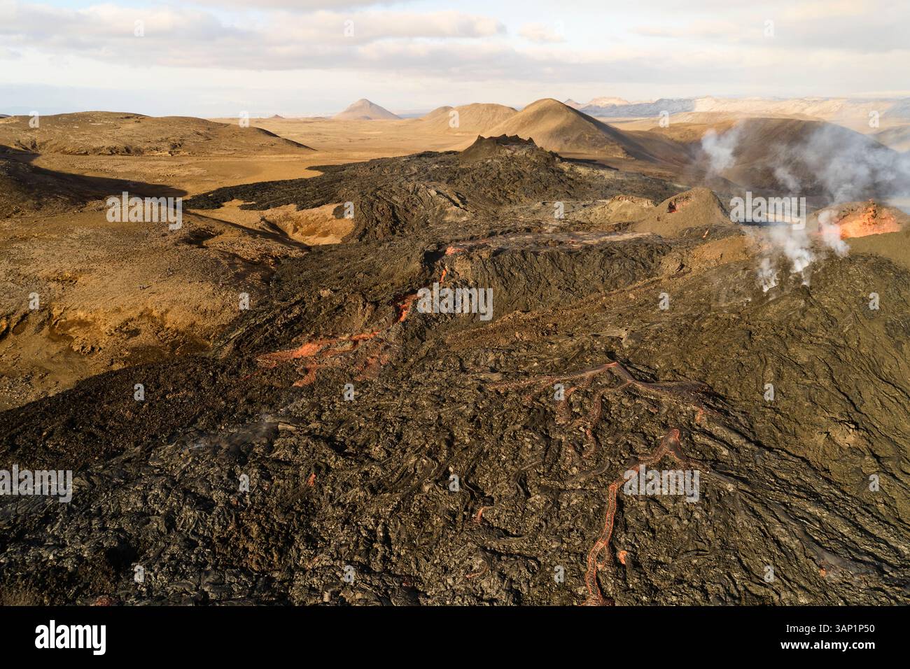 Aerial view of dry magma along mountain crest with few craters smoking ...