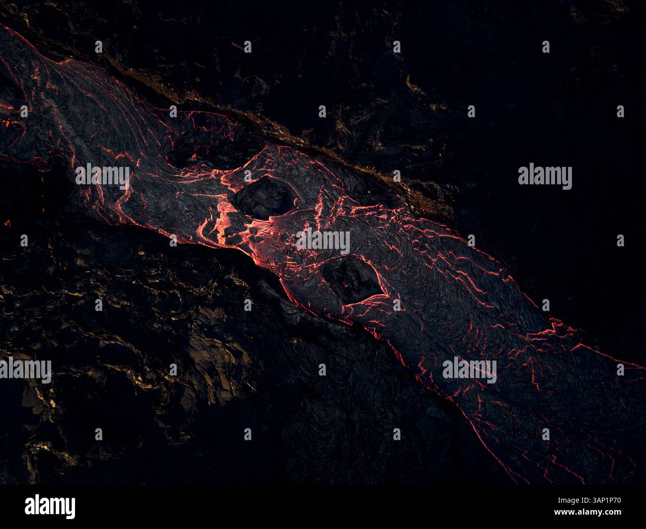 Aerial view of lava streaming down the mountain ridge, view of a river ...