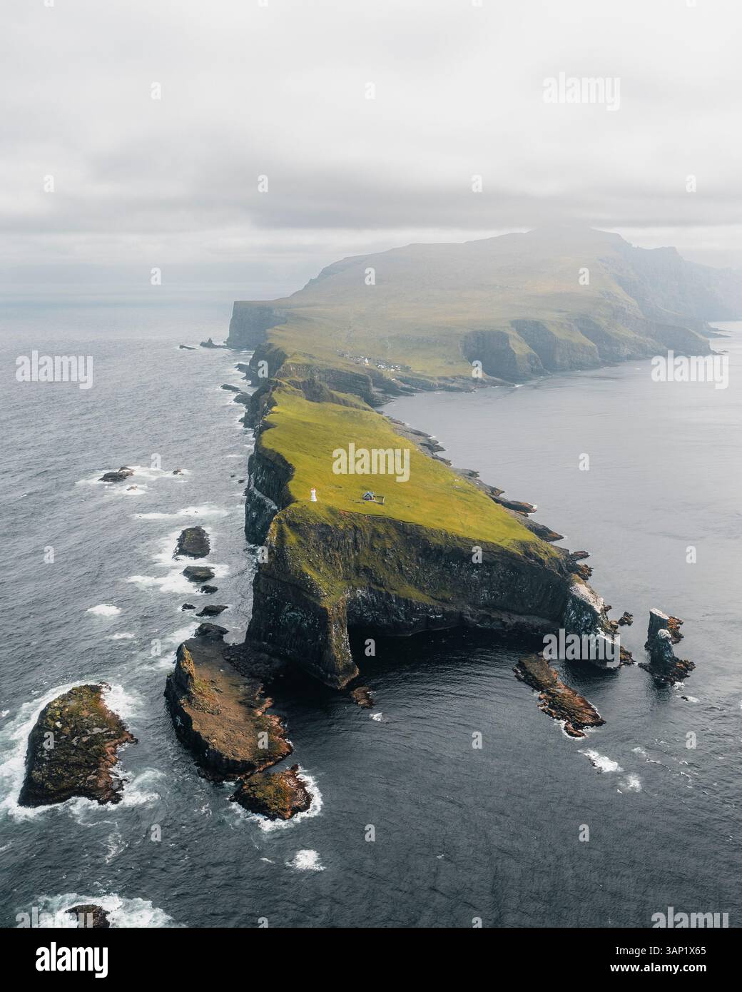 Aerial view of mykines lighthouse on a rugged cliff overlooking the ...