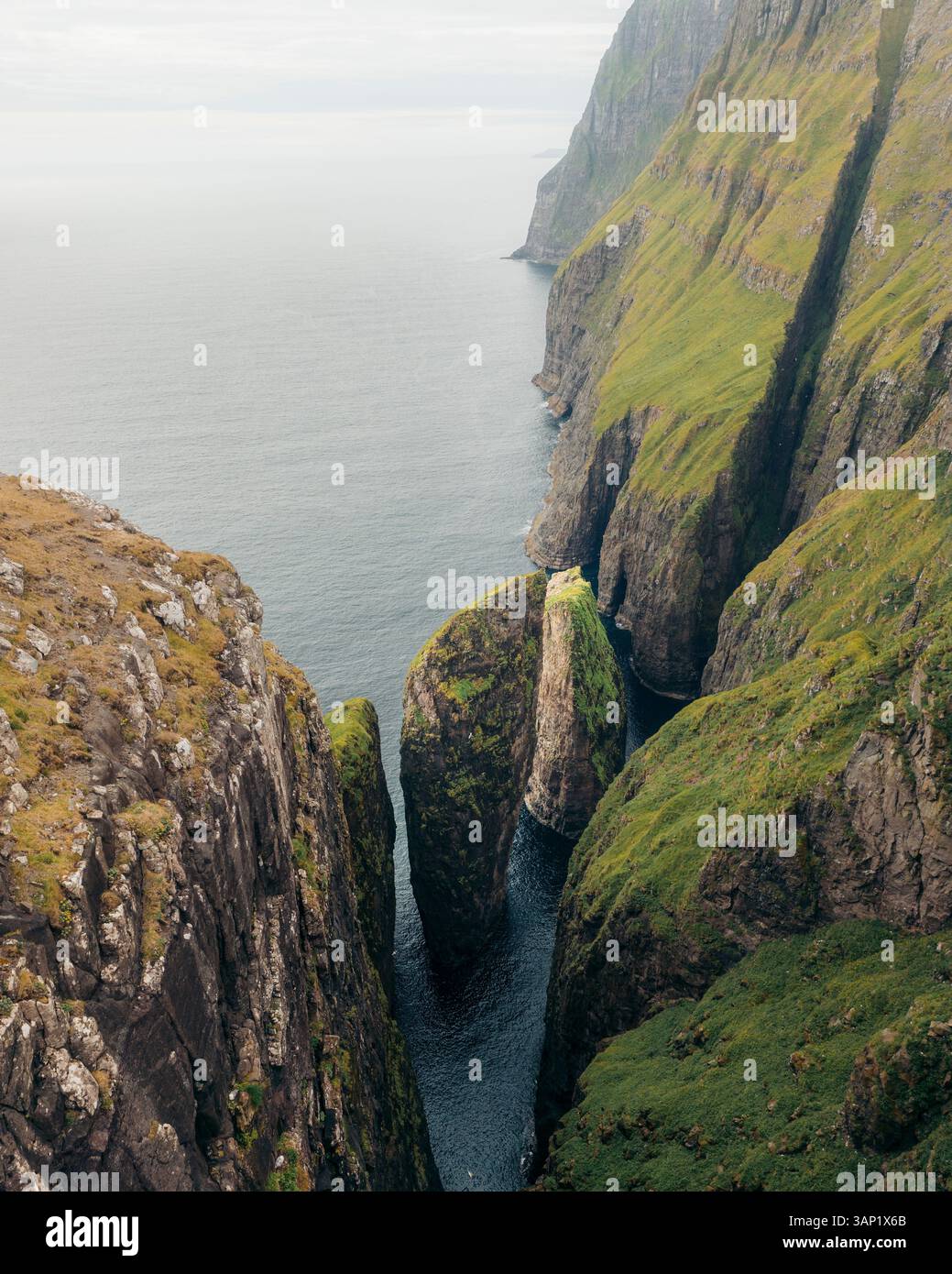 Aerial view of dramatic cliffs and pristine ocean with rugged rock ...