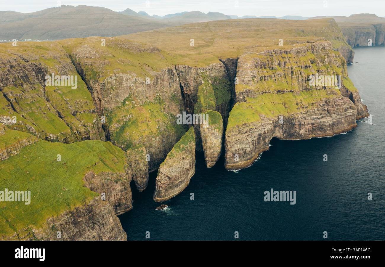 Aerial view of majestic cliffs and the tranquil ocean with lush ...