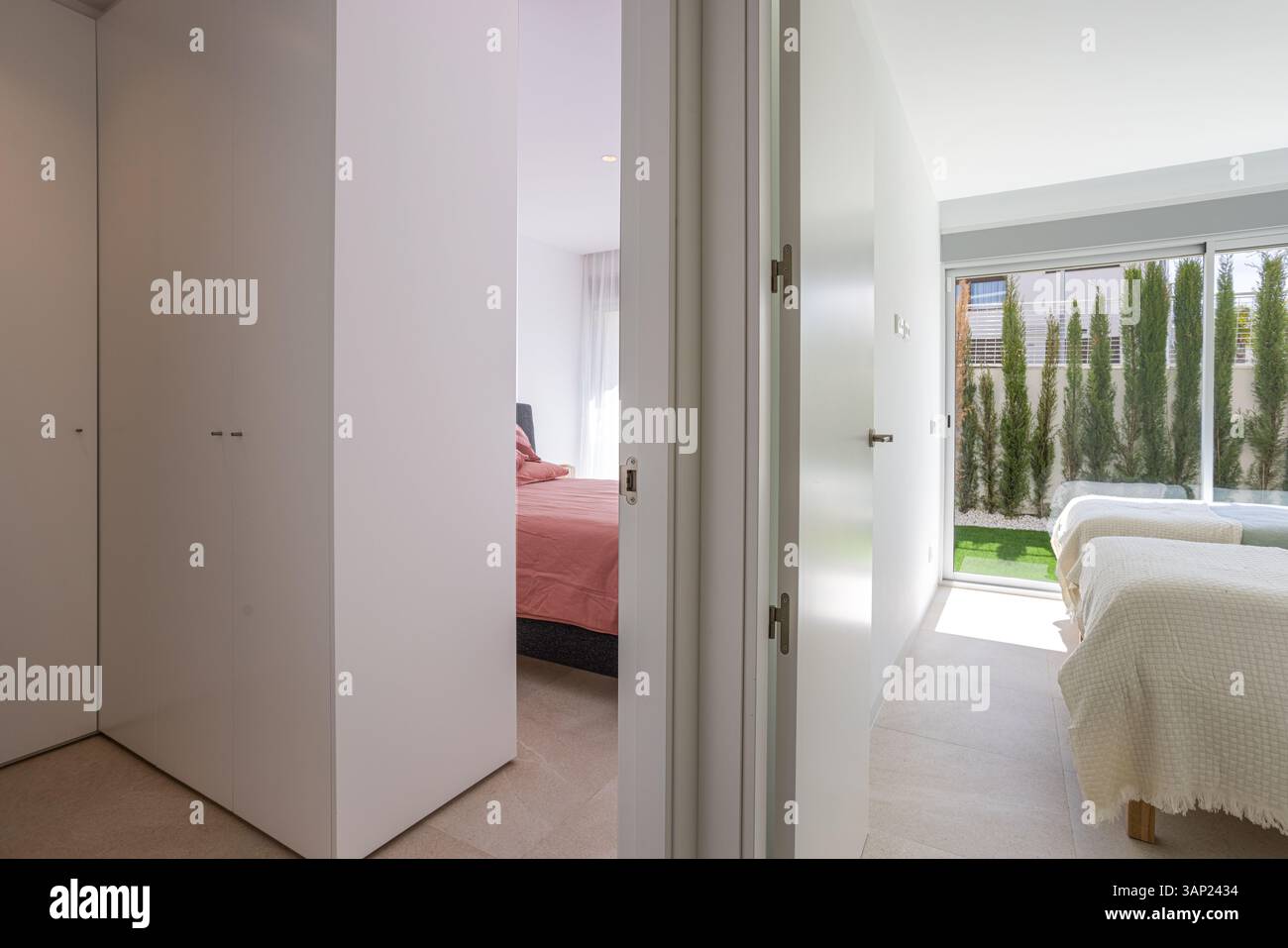 Minimal corridor connecting bedrooms with large windows offering a view ...