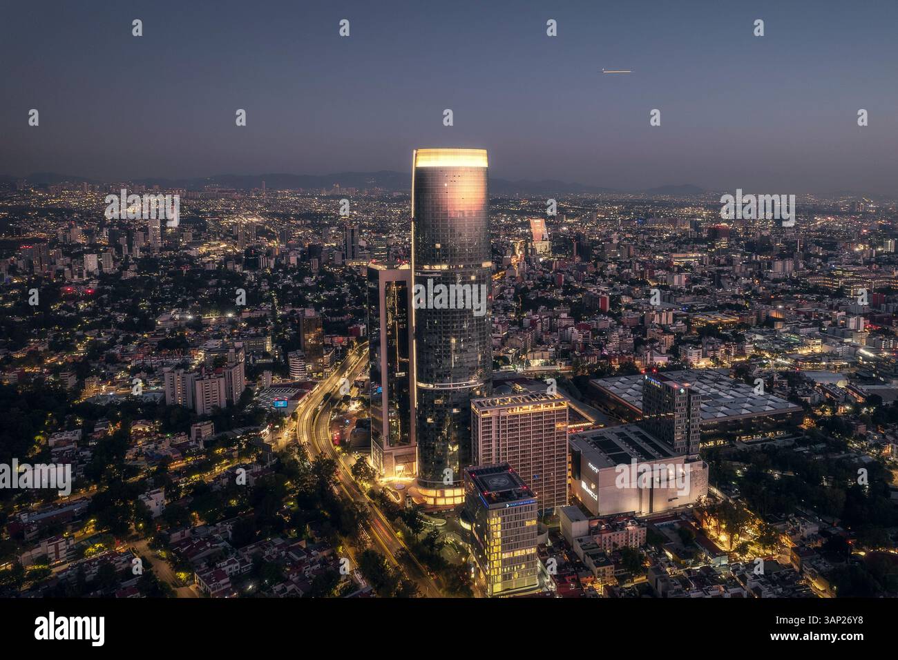 Aerial view of mitikah tower at sunrise over the urban skyline ...