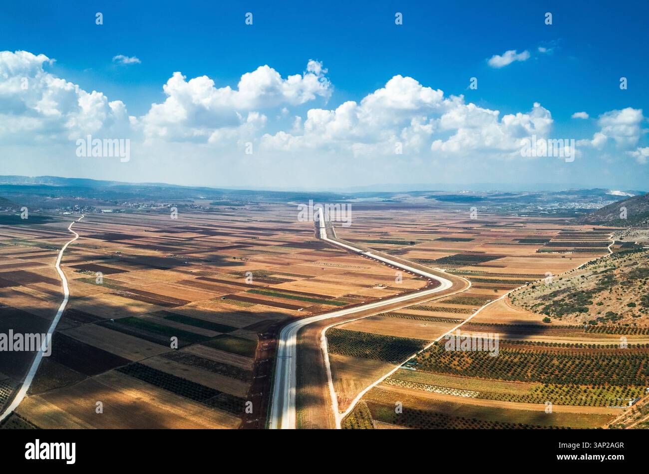 Aerial view of a road crossing the countryside with agricultural fields ...