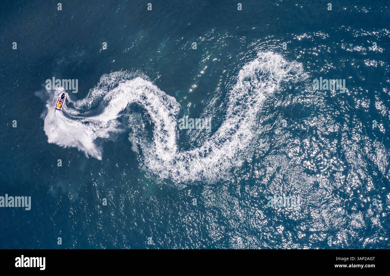 Aerial view of a water bike forming a white snake like trail in the ...