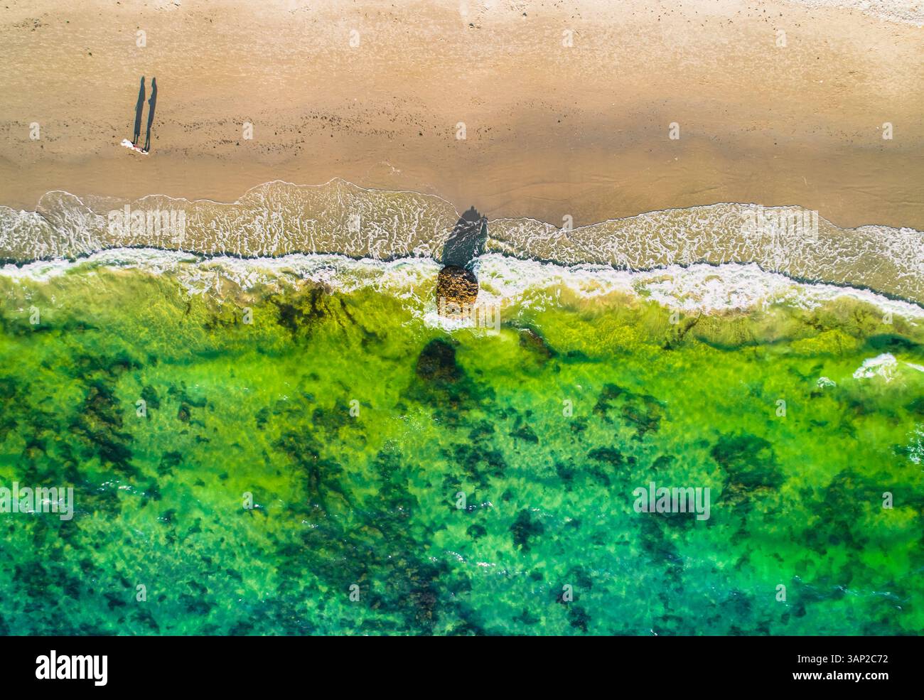 Aerial view of two person on the beach along the shoreline, Apollonia ...