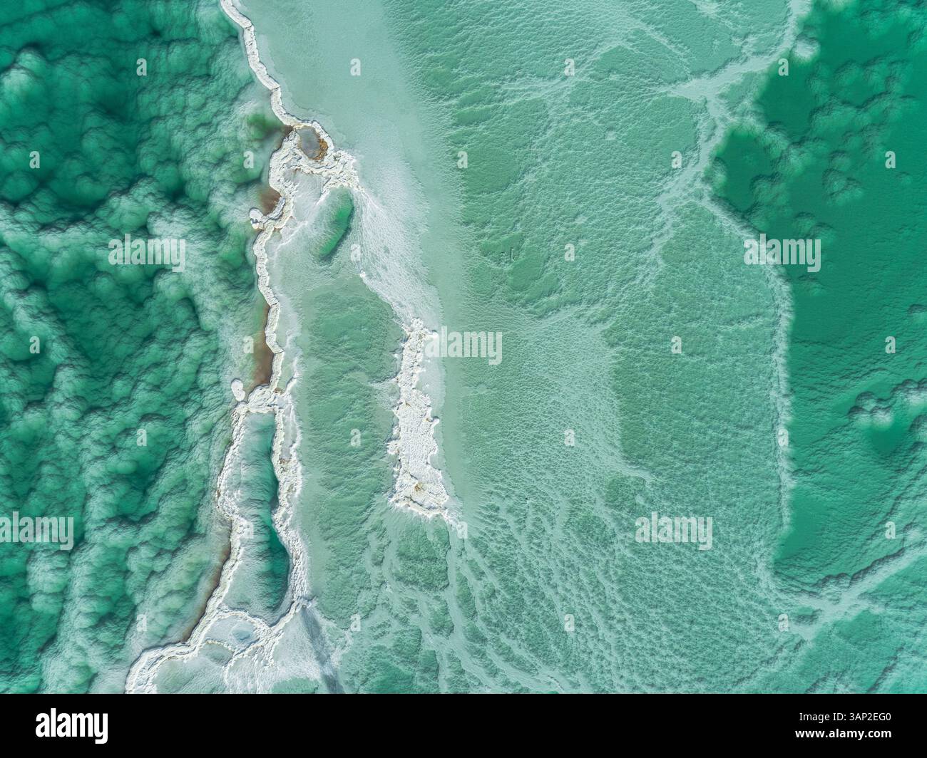Aerial view of salt texture with veins in the shallow water of the Dead ...