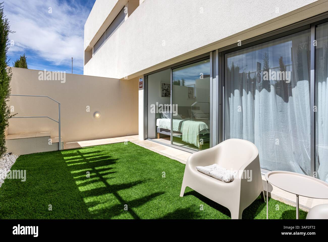 Artificial grass garden with seating area outside two bedrooms ...