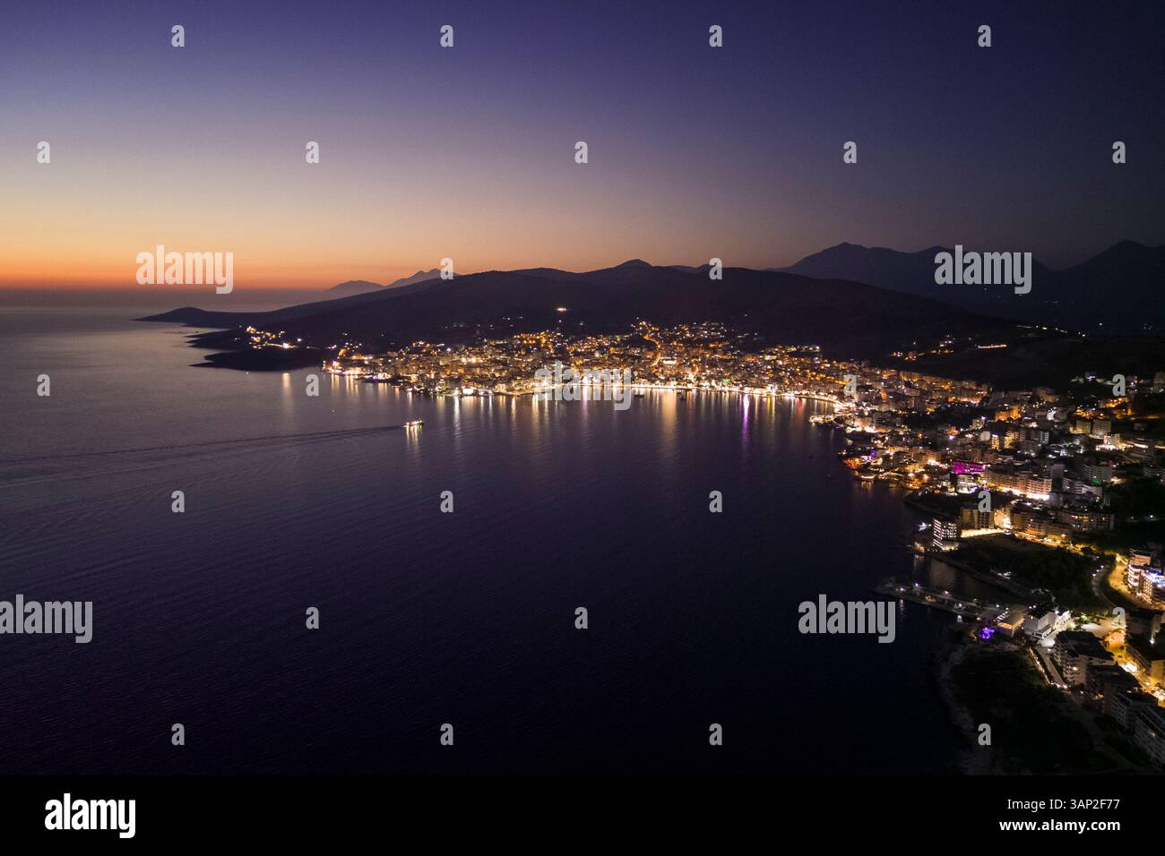 Aerial view of saranda city illuminated at night with a picturesque ...